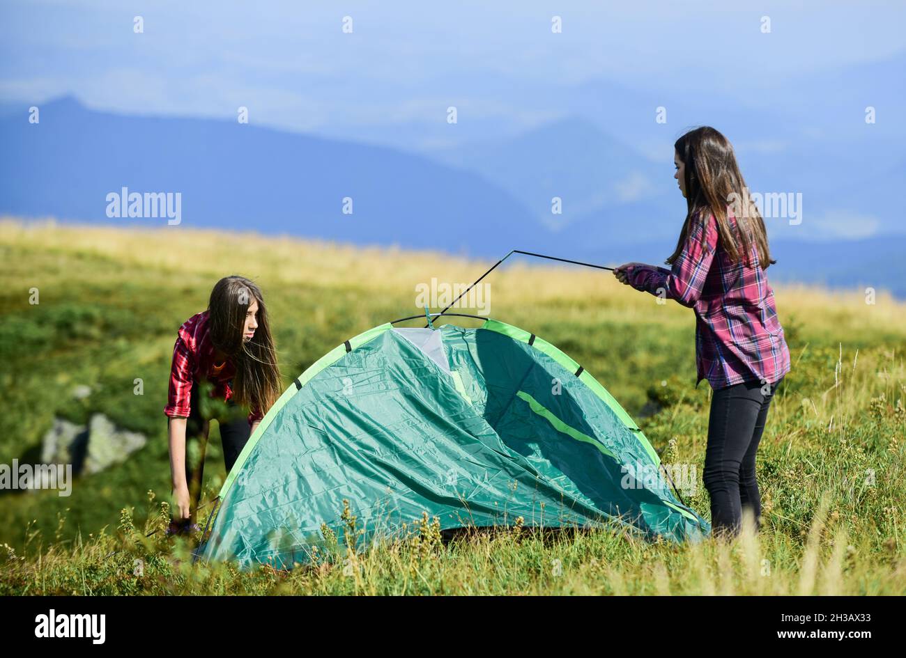 Girl scout concept. Women set up tent on top mountain. Camping hiking ...