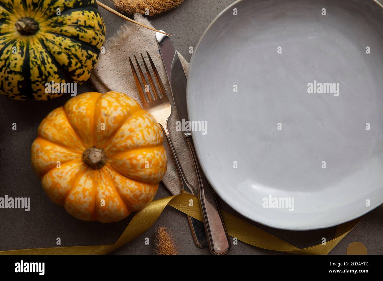 Overhead autumn thanksgiving dinner place setting with pumpkins cutlery ...