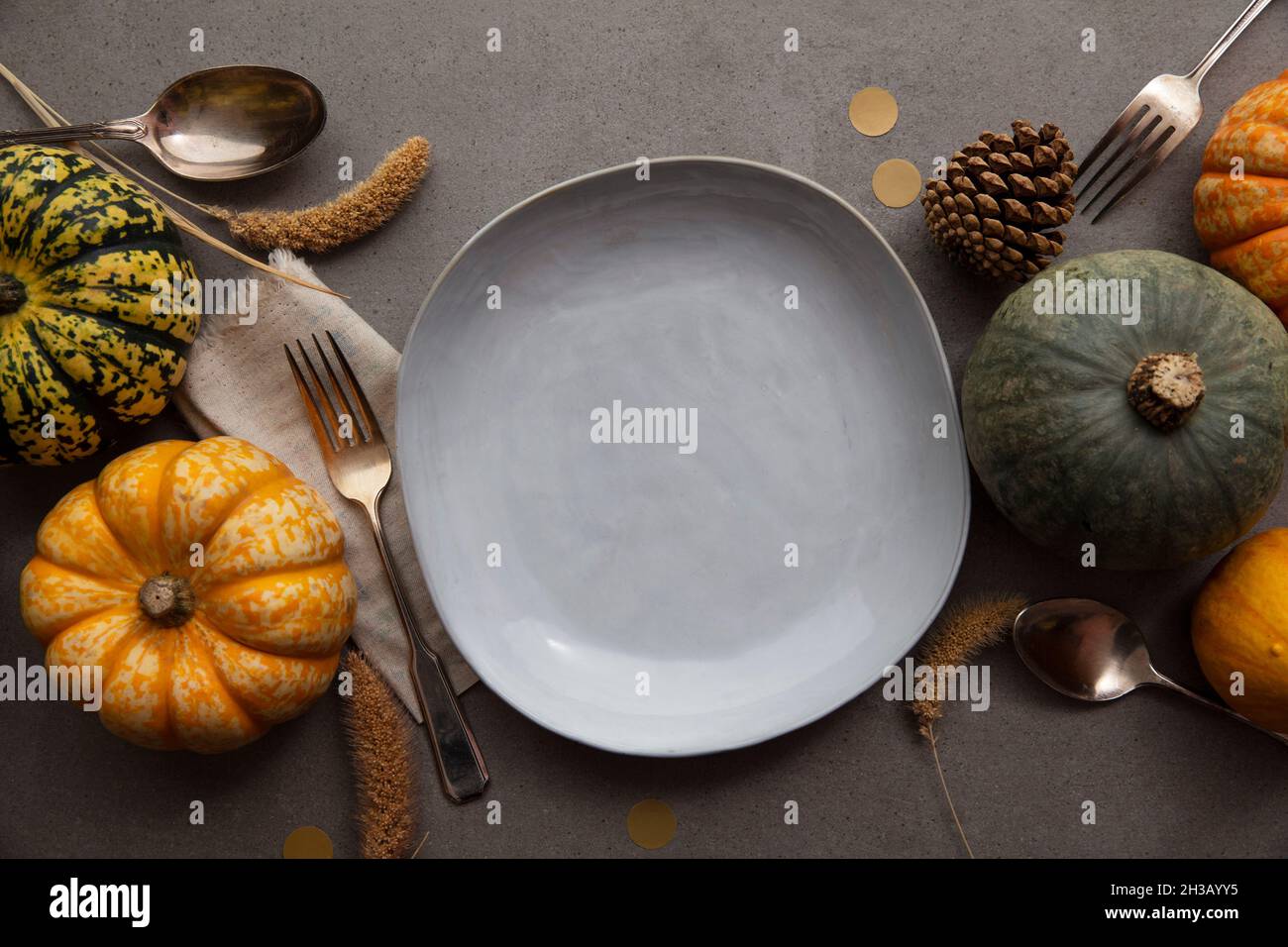 Overhead autumn thanksgiving dinner place setting with pumpkins cutlery ...