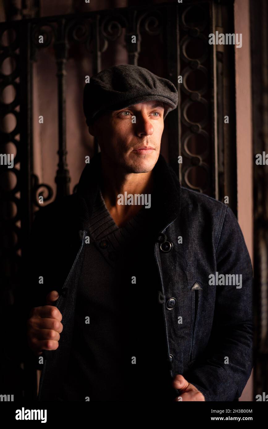 A man in a coat and cap walks around the city Stock Photo - Alamy