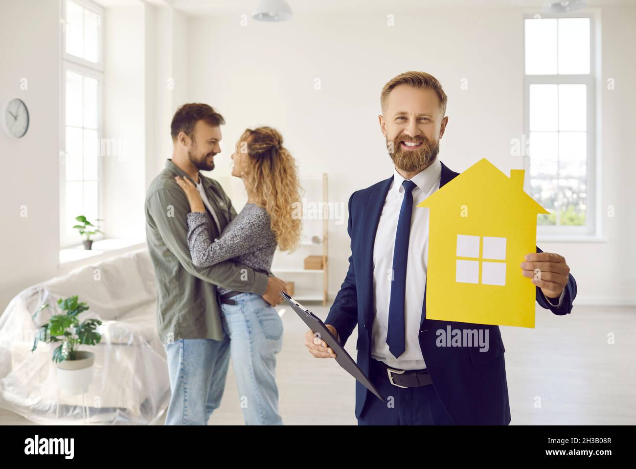 Real estate agent standing in new house that he has just sold to his ...