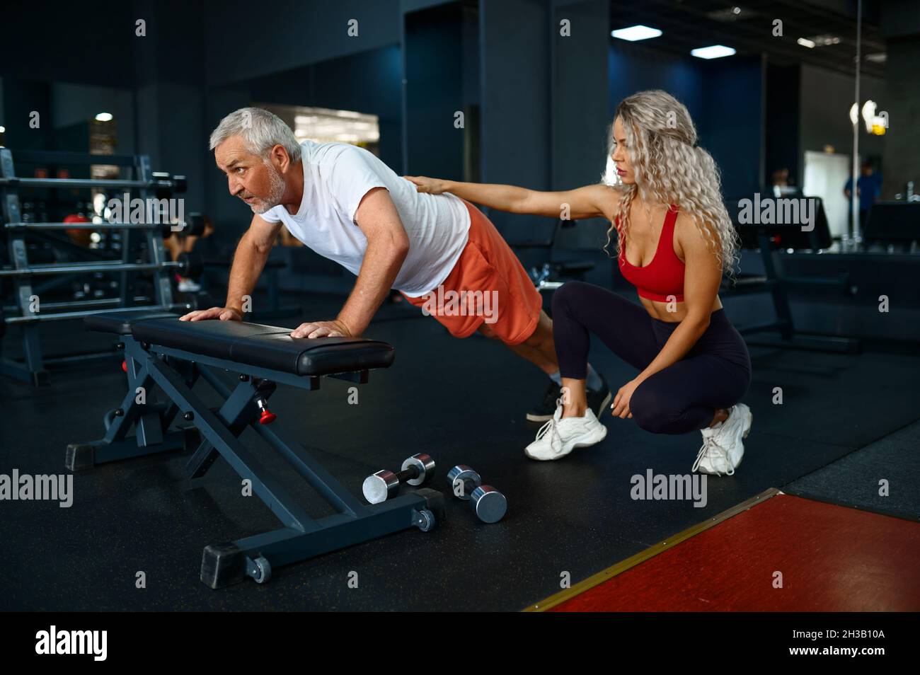 Old man, push-up exercise on bench, female trainer Stock Photo - Alamy