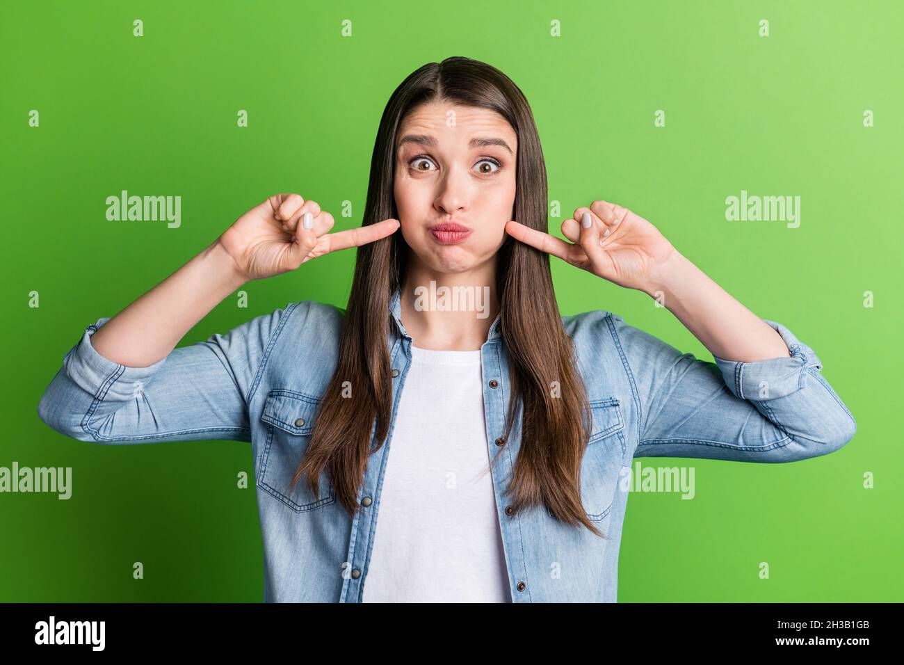Portrait of attractive cheerful funky girl pressing cheek holding air ...