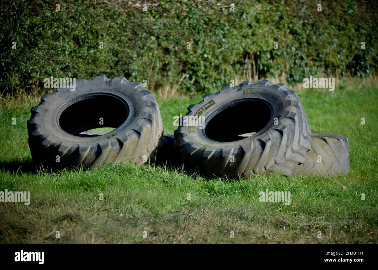Four used tractor tyres left in a field Stock Photo - Alamy