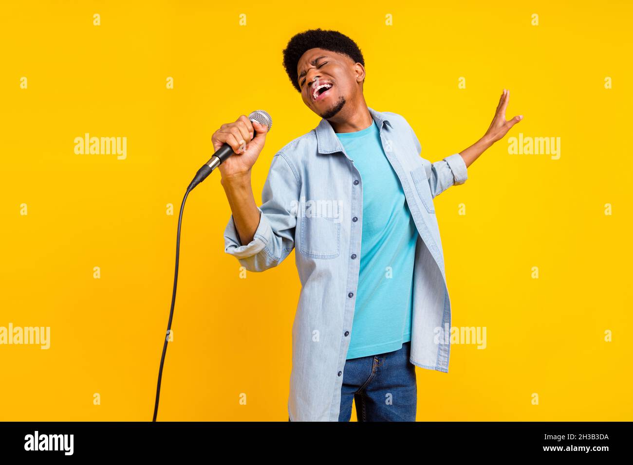 Photo of cute attractive dark skin guy dressed denim shirt singing ...
