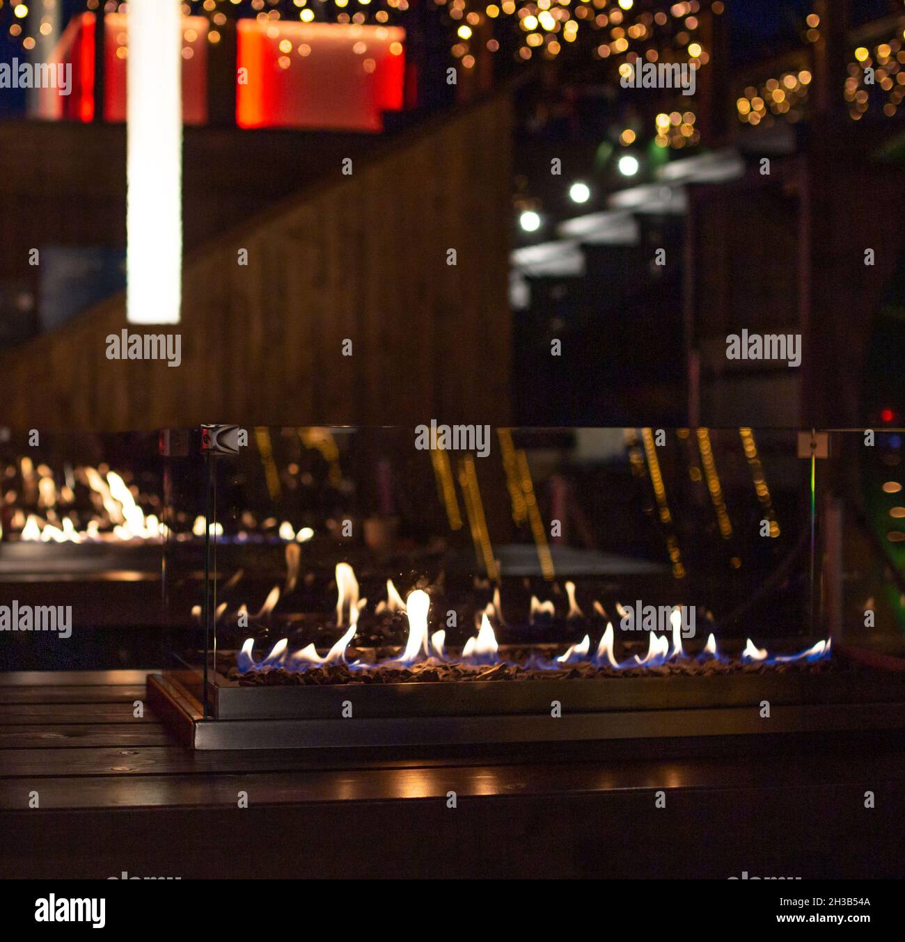 close up of fireplace with burning fire wood in cold winter night and ...