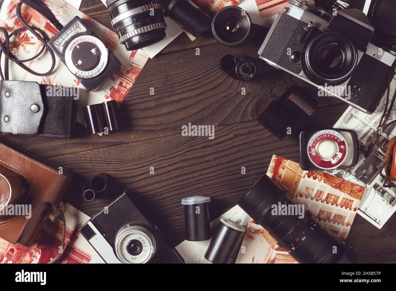 Old outdated photo cameras, lenses and exposure meters on wooden ...