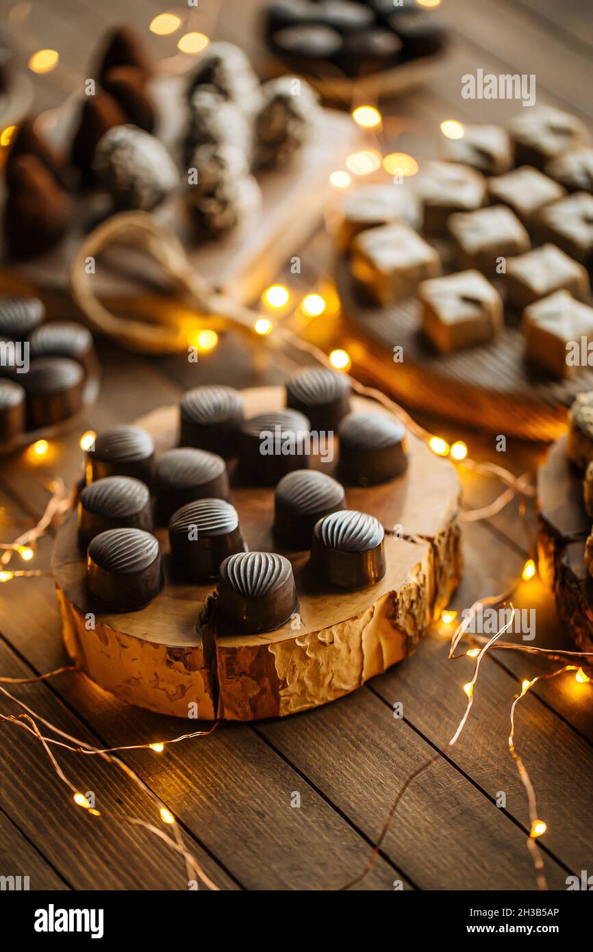 Assorted chocolates on wooden table with garland Stock Photo - Alamy