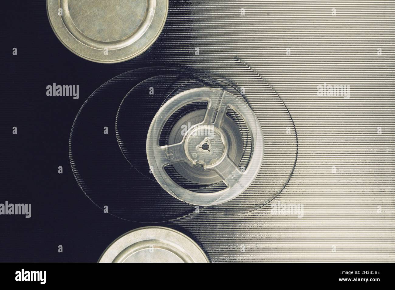 Old spools with black and white film stock and boxes on black ...