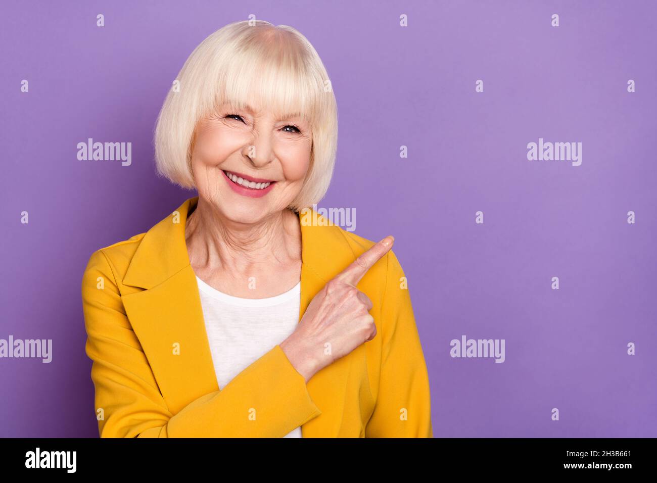 Portrait of cheerful charming person indicate finger empty space toothy ...