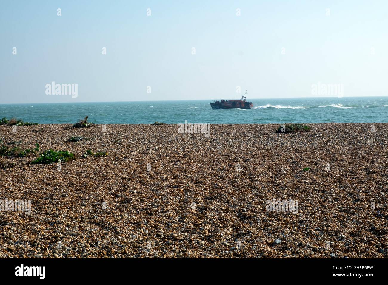 People on an RNLI Lifeguard boat sailing in the sea on the coast and ...