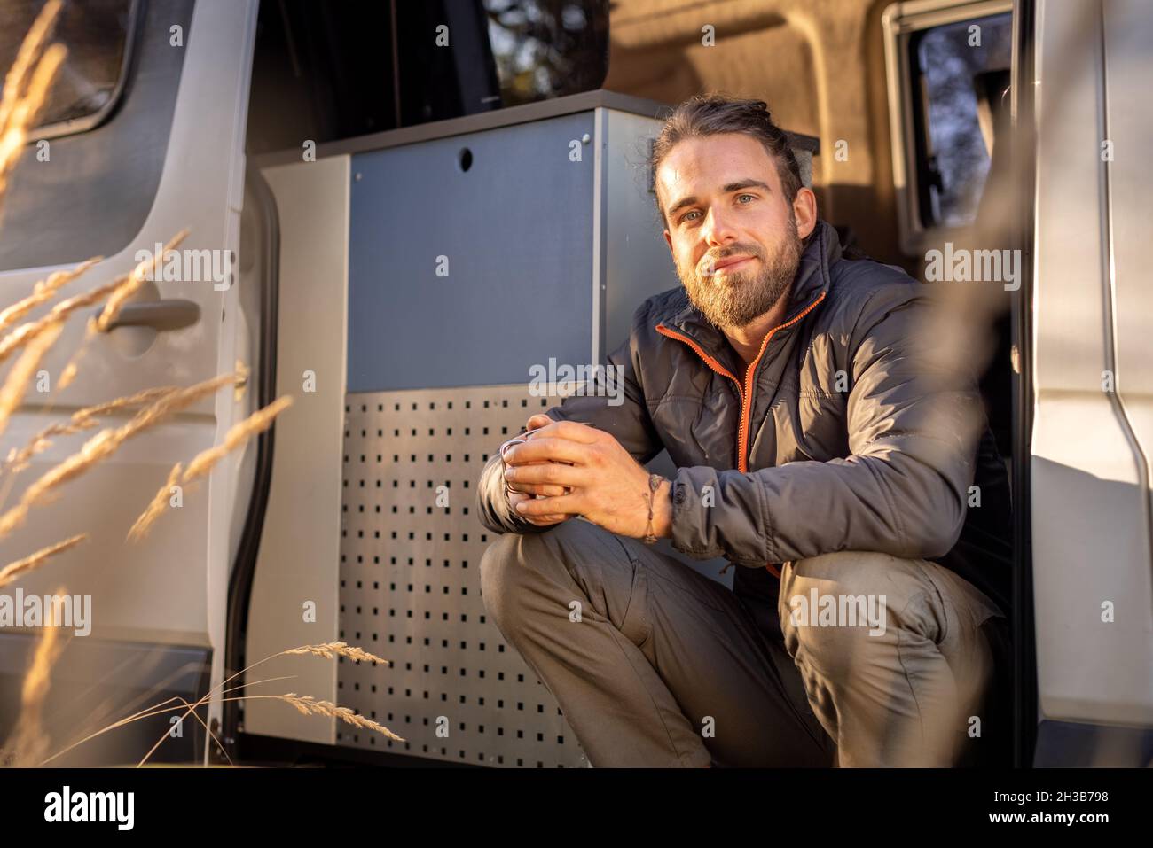 Portrait of a man sitting in his camper van Stock Photo - Alamy