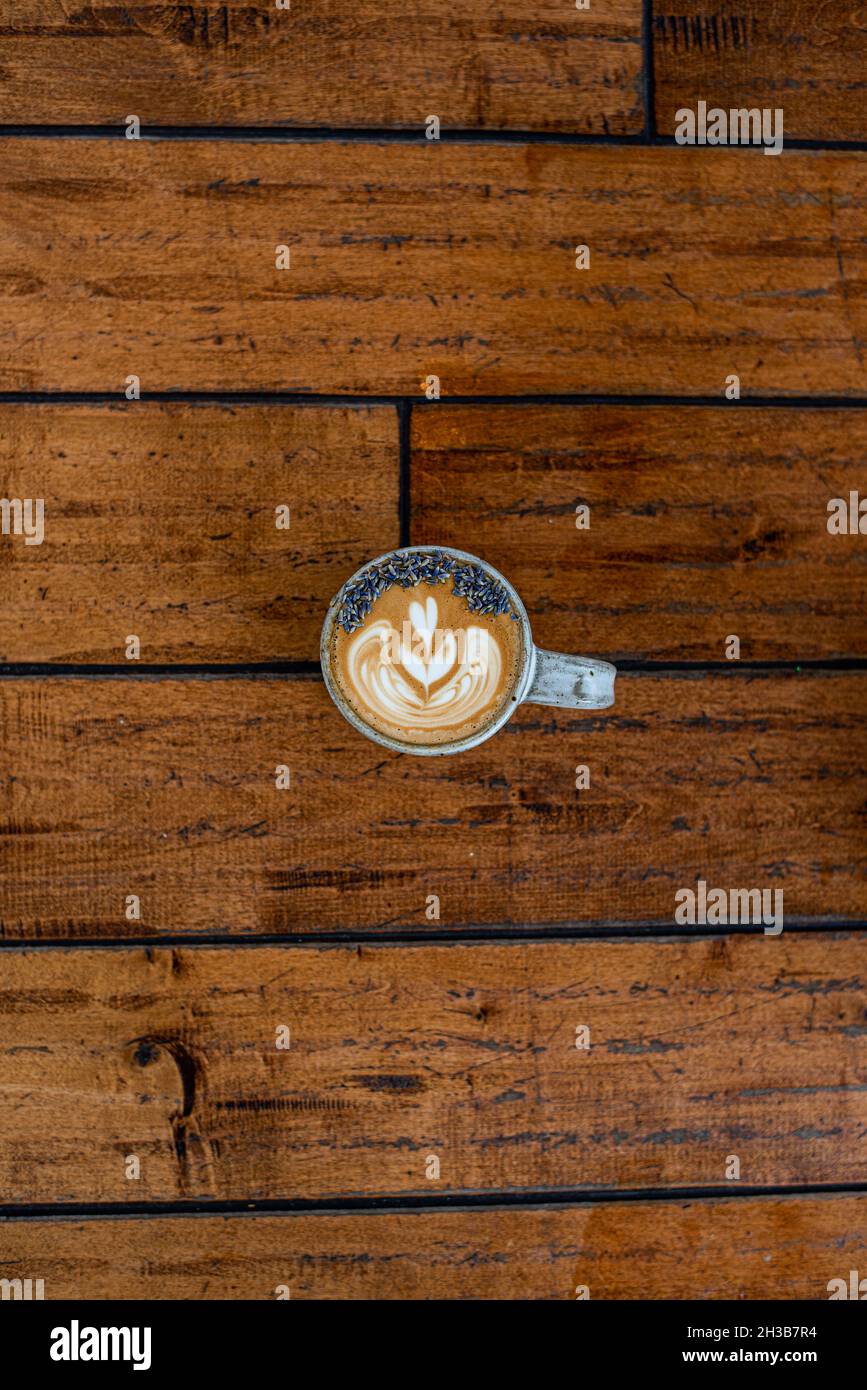 Lavender latte on wood floor with rosetta latte art and lavender dried ...