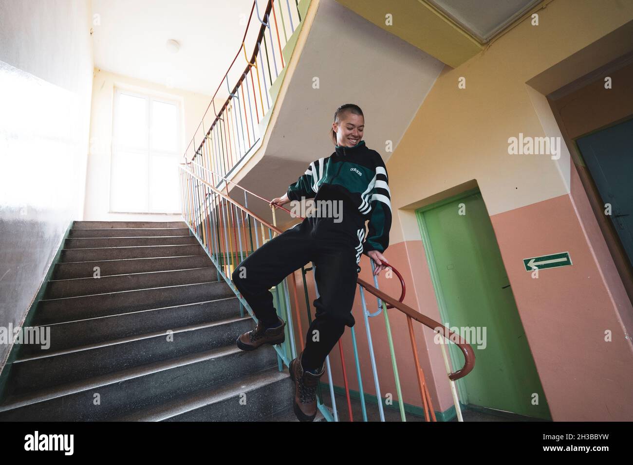 athletic androgynous strong woman slides down railing and laughs Stock ...