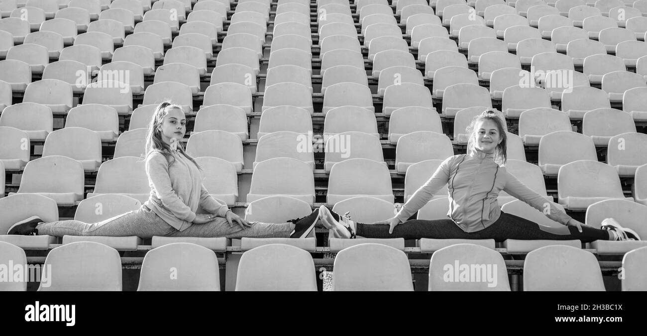 girls kids training sport outside on stadium tribune sit in split ...