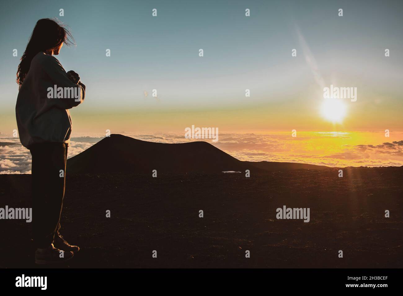 female watches sunset on top of Mauna Kea Stock Photo - Alamy