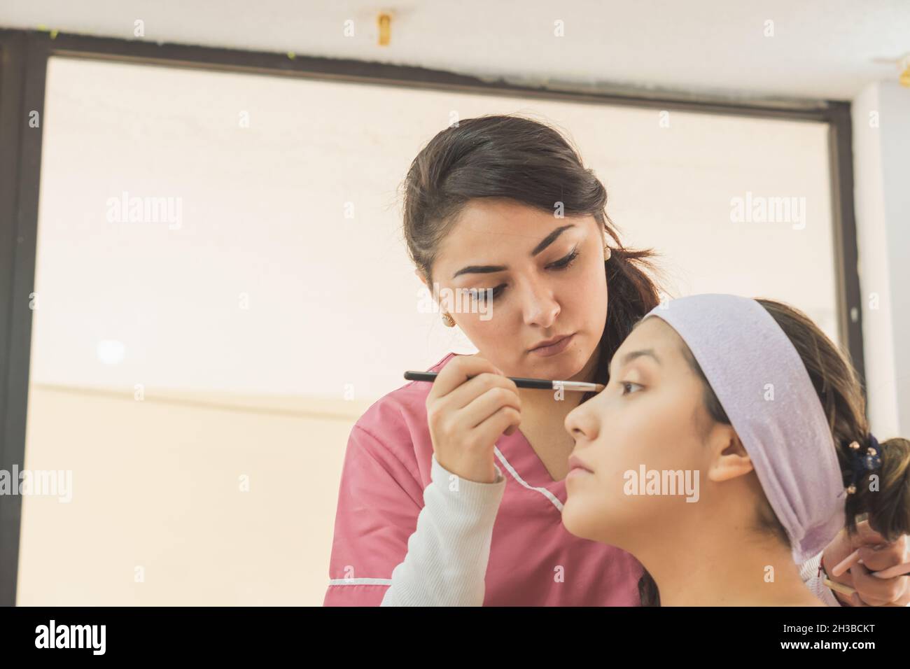 Young woman getting ready to put on makeup for a special event. In a makeup center enjoying this ...