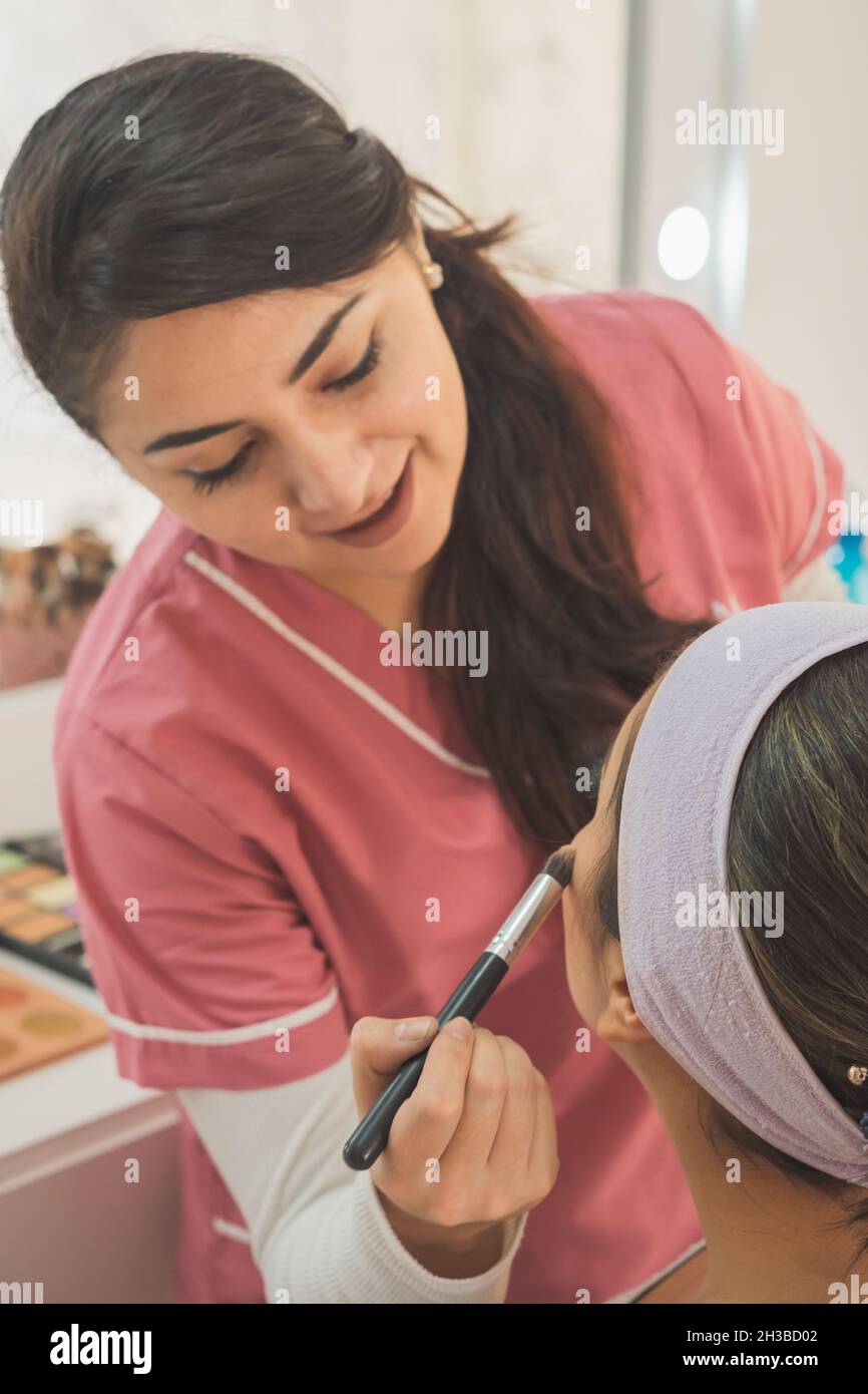Young woman getting ready to put on makeup for a special event. In a makeup center enjoying this ...