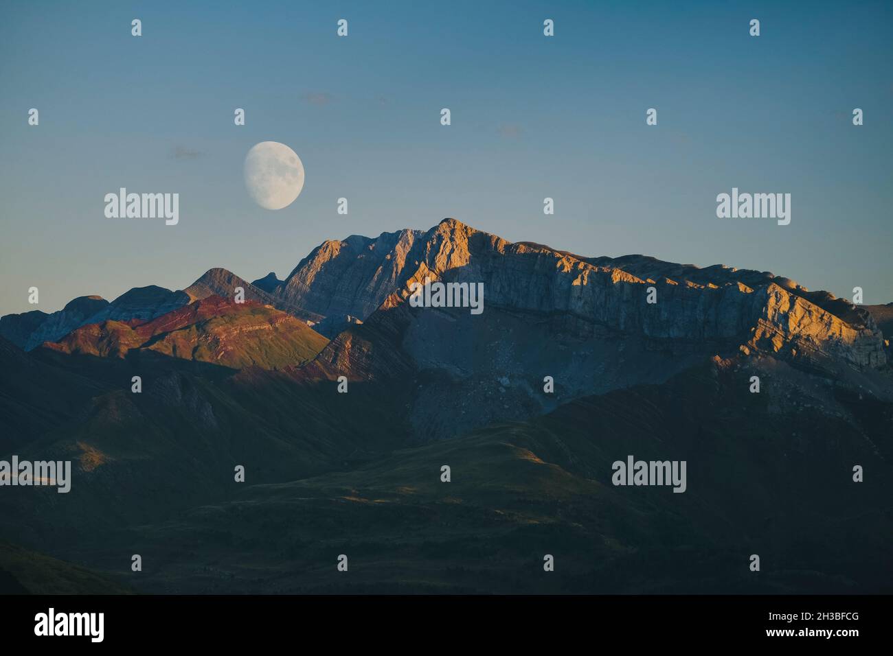 Moon rising behind high mountain peaks at sunset, Pyrenees Stock Photo ...