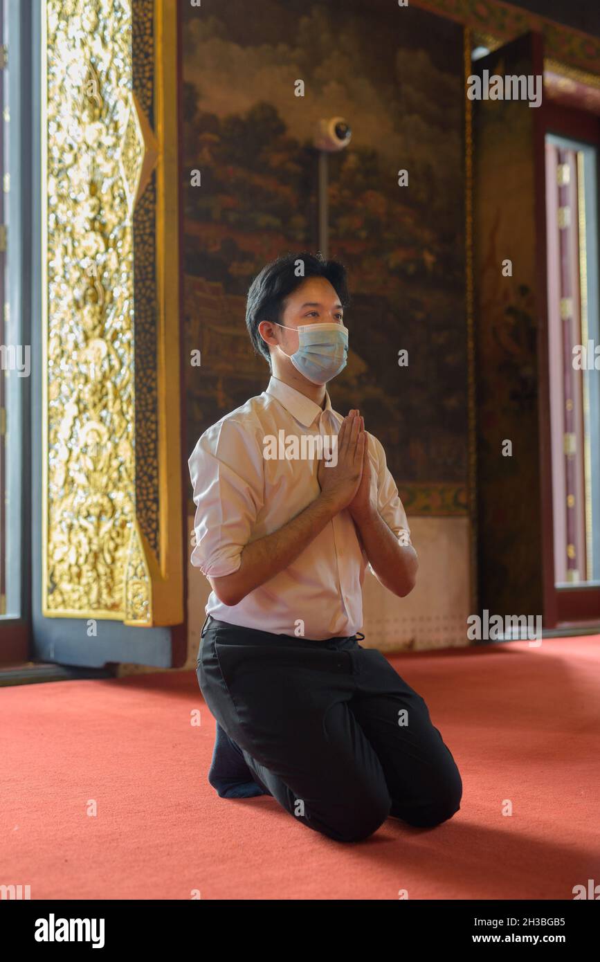 Portrait of man in Buddhist temple praying and respecting traditional ...