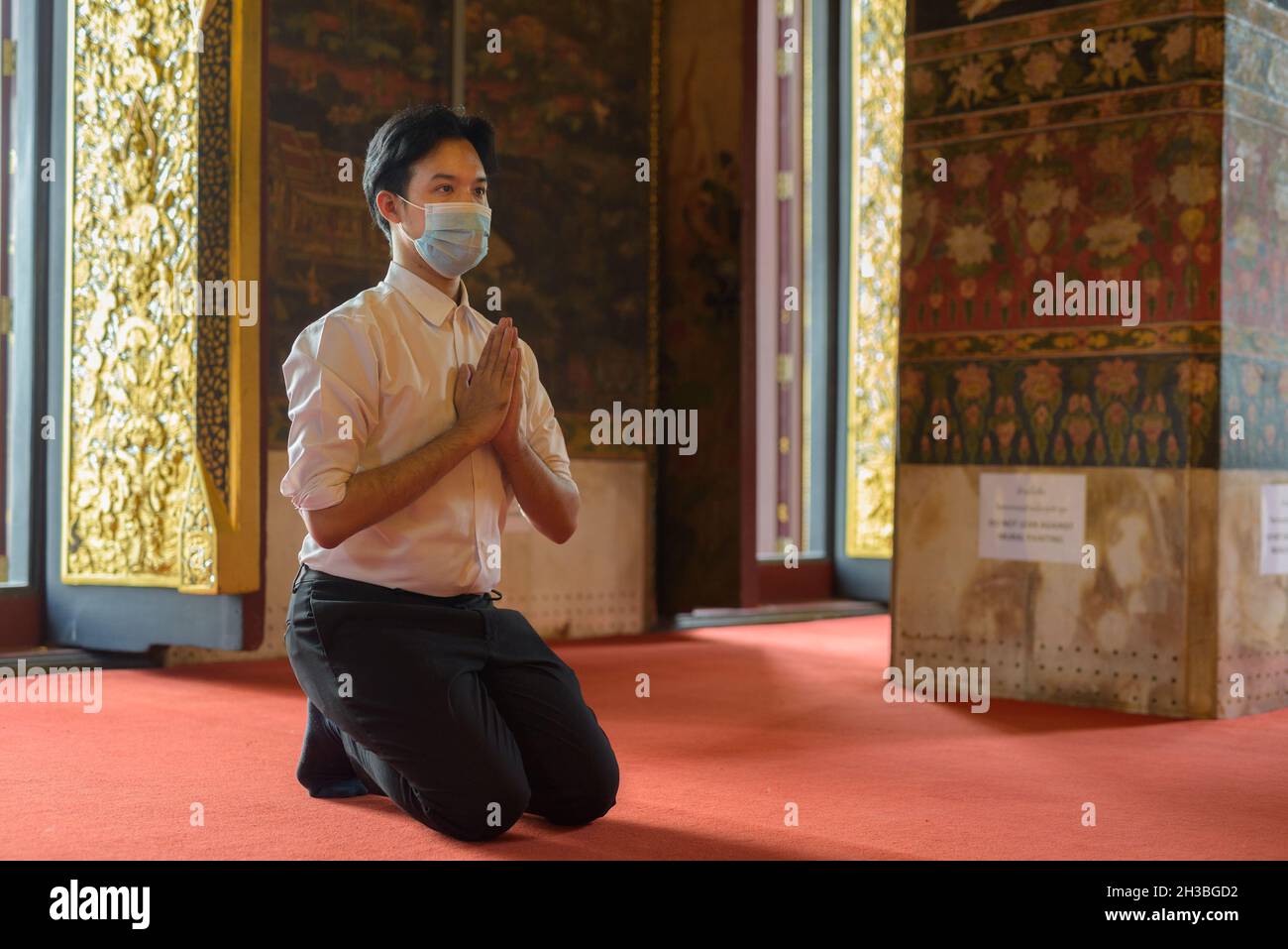 Portrait of man in Buddhist temple praying and respecting traditional ...