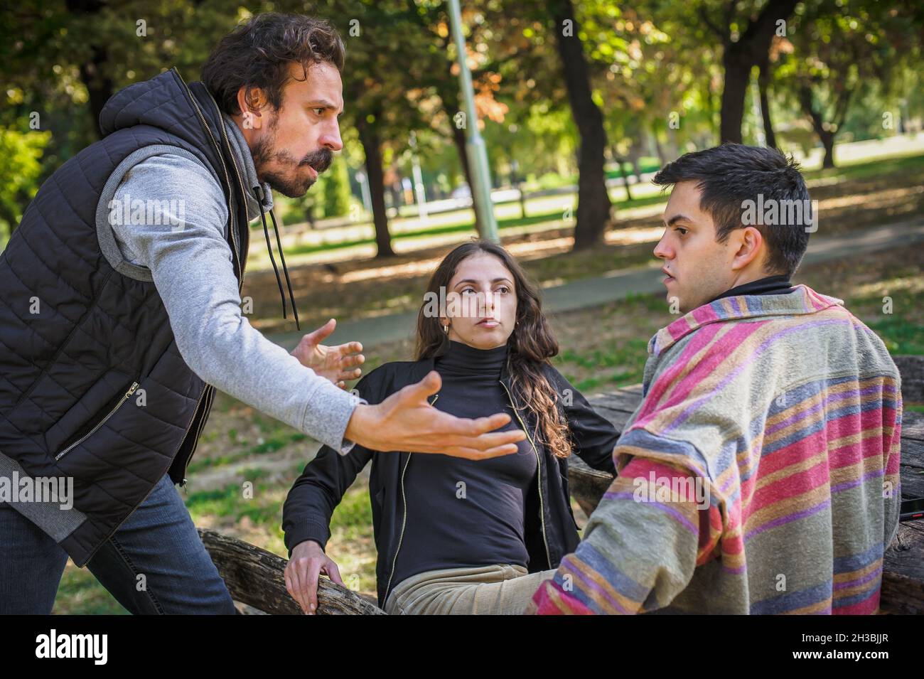 Three angry, nervous and upset friends, two men and a woman in a fierce ...