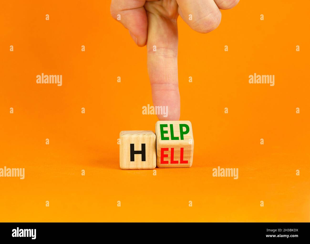 Hell or help symbol. Businessman turns a cube and changes the word ...