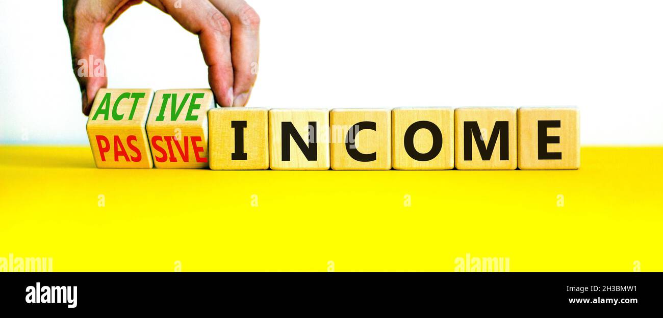 Passive or active income symbol. Businessman turns wooden cubes and ...