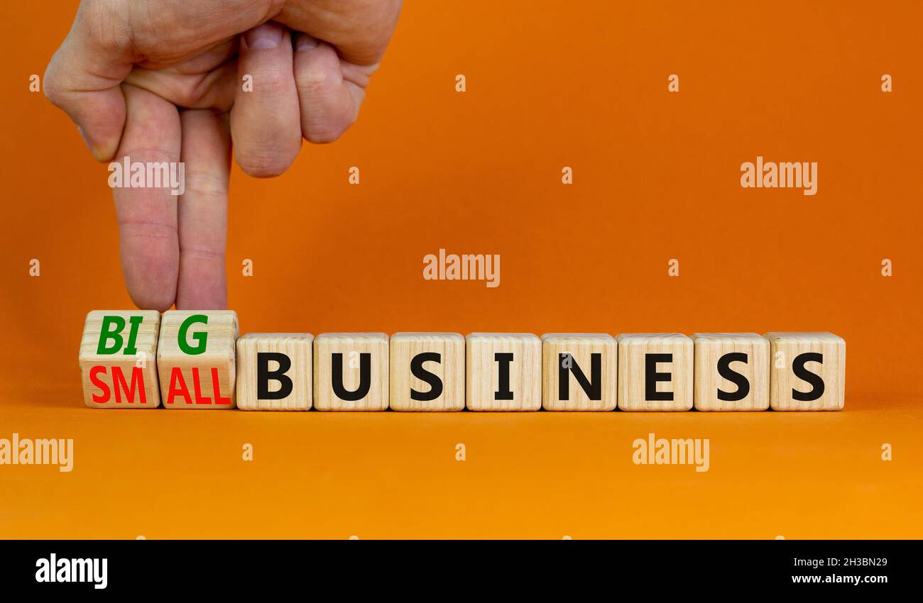 Big or small business symbol. Businessman turns wooden cubes, changes ...