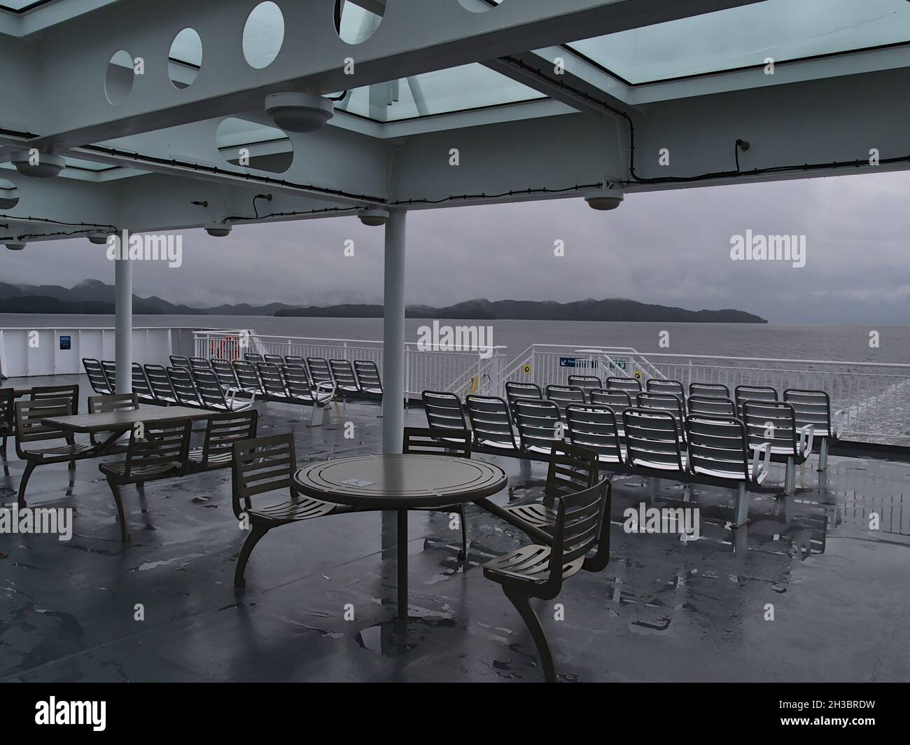 Empty seats on the rear deck of ferry vessel passing the Canadian coast ...