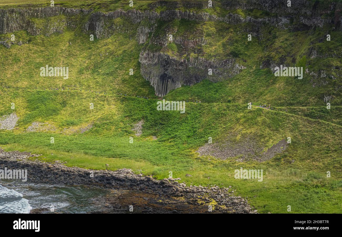 Tourists admiring The Amphitheatre in Giants Causeway, seen from top of ...