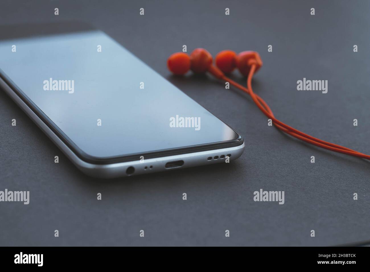 Mobile phone and headphones. Cell phone with black display Stock Photo ...