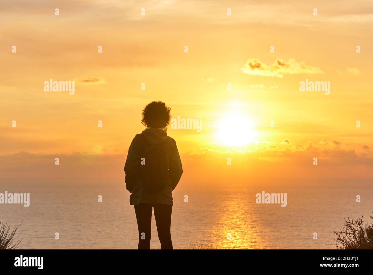Back woman backpack looking sunset hi-res stock photography and images ...