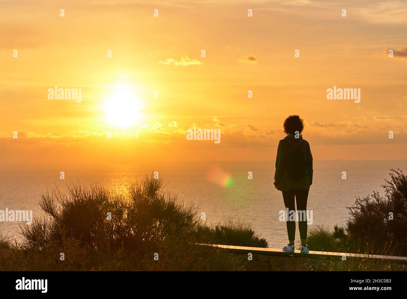Back woman backpack looking sunset hi-res stock photography and images ...