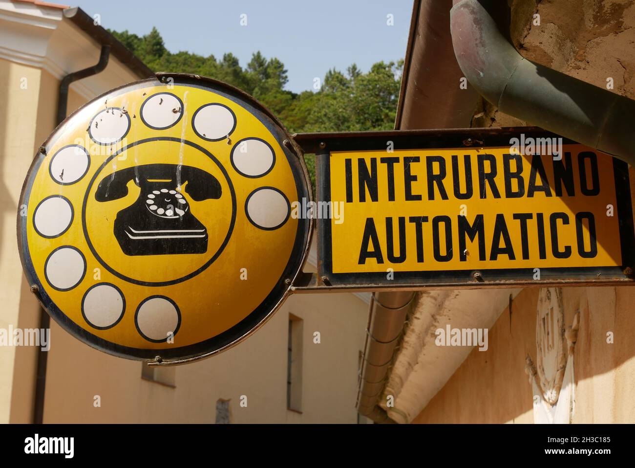 Yellow phone sign attached to a building Stock Photo - Alamy