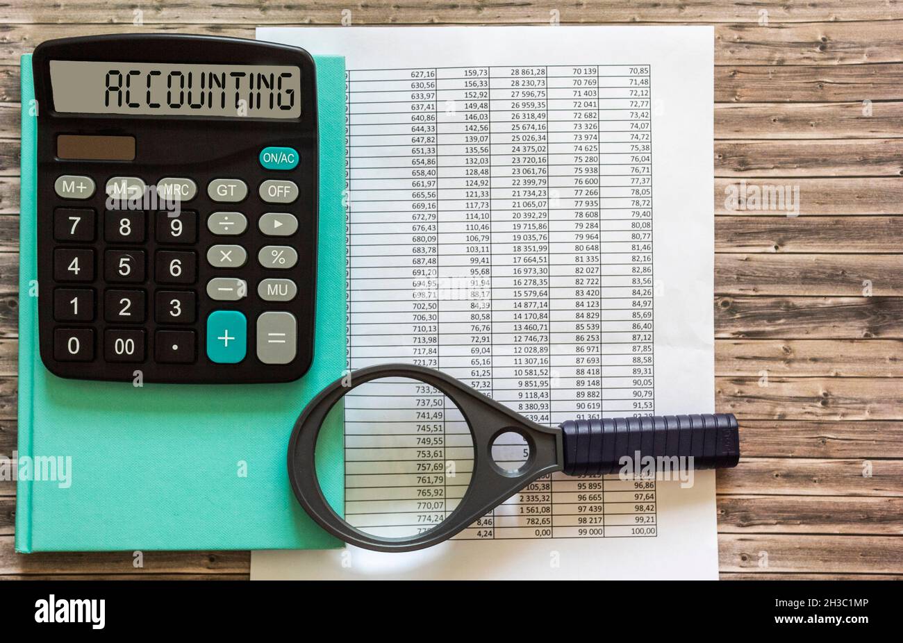 Accounting, text on calculator, near a magnifying glass, documents with ...