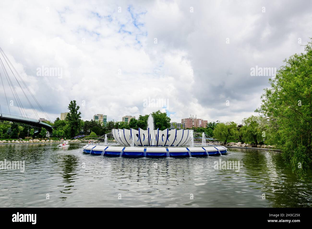 Landscape with the lake, decorative fountain and vivid green trees in ...