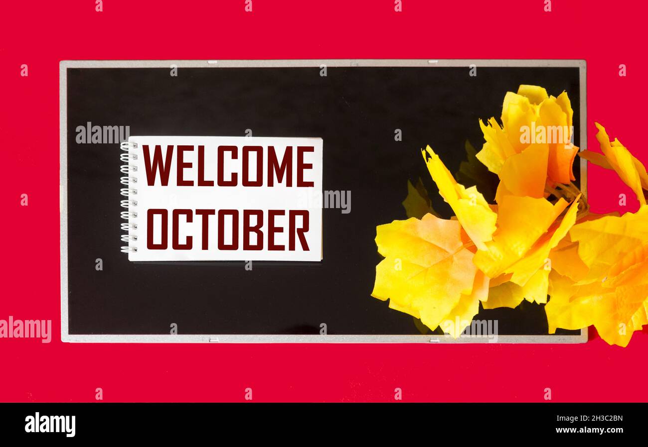 Note with welcome October text on notepad and black and red background ...