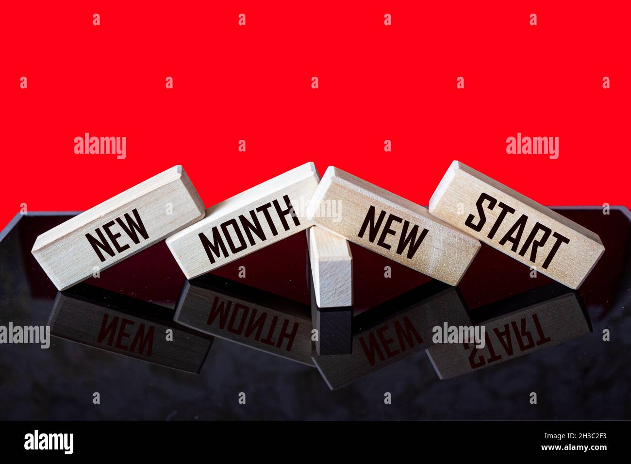 The text NEW MONTH NEW START on a red-black background is written on ...