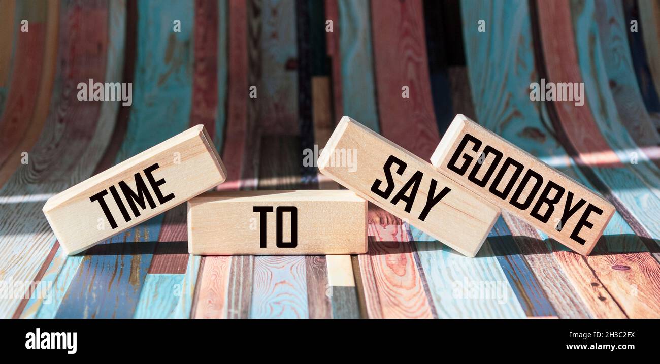Text TIME TO SAY GOODBYE on wooden blocks and bright striped background ...