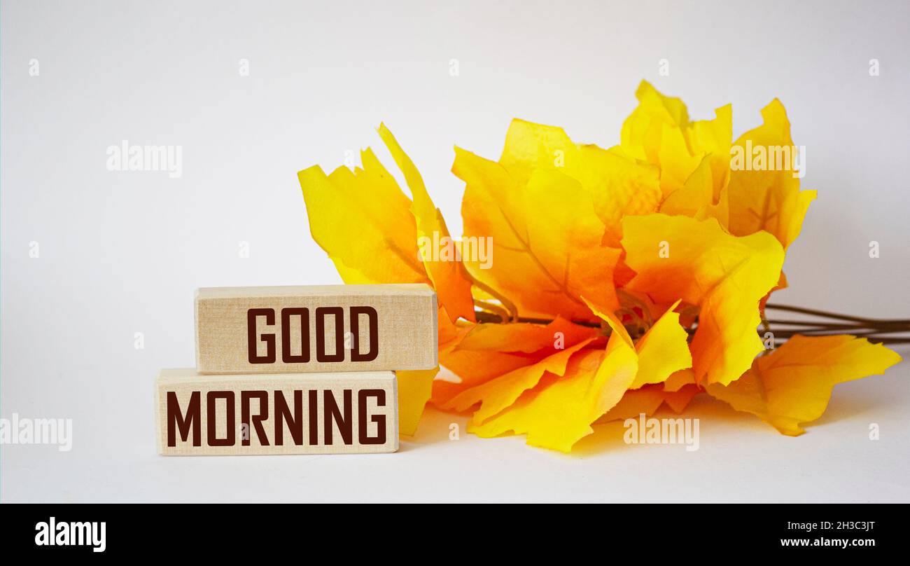 Good morning written on wooden blocks and white background with yellow ...