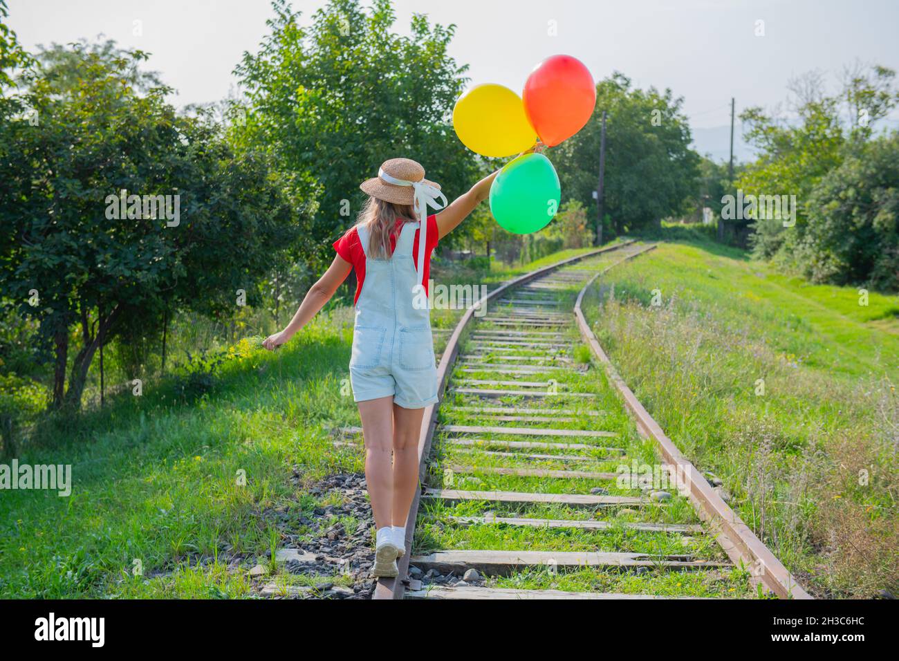 tourist walks with balls on the railroad Stock Photo - Alamy