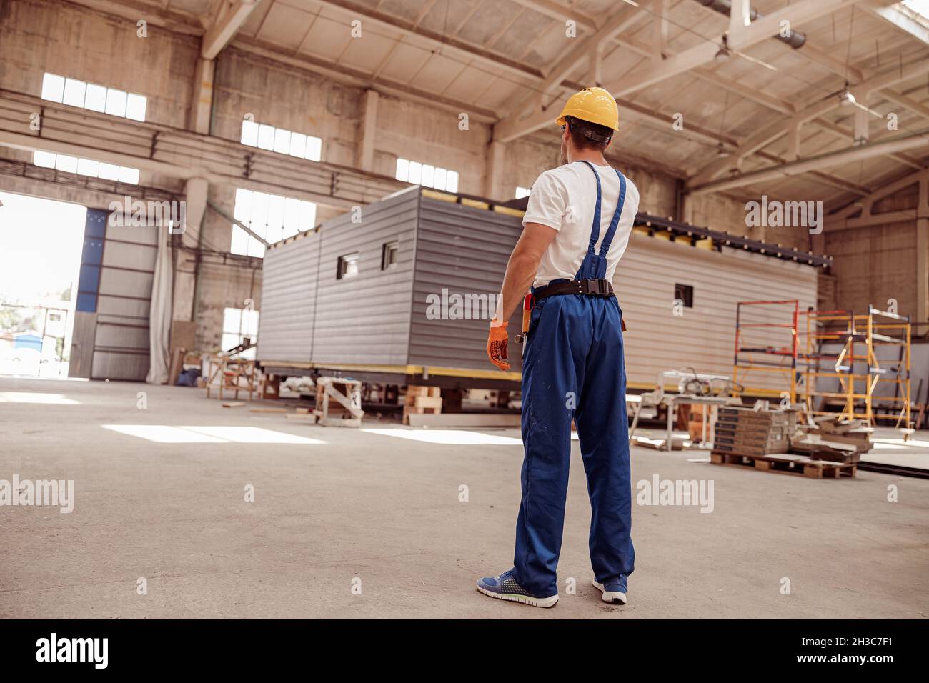 Male builder standing inside building with construction cabin Stock ...
