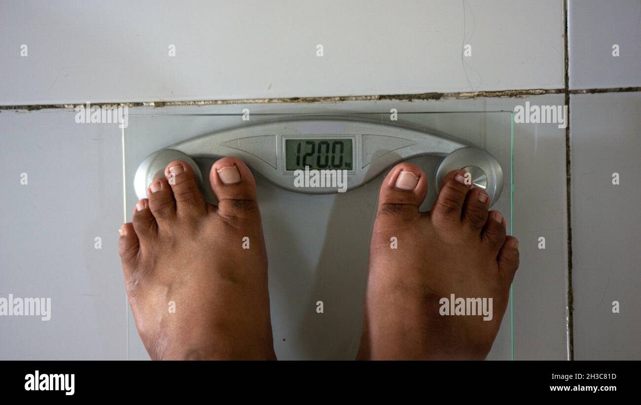 Feet on electronic scales Stock Photo - Alamy