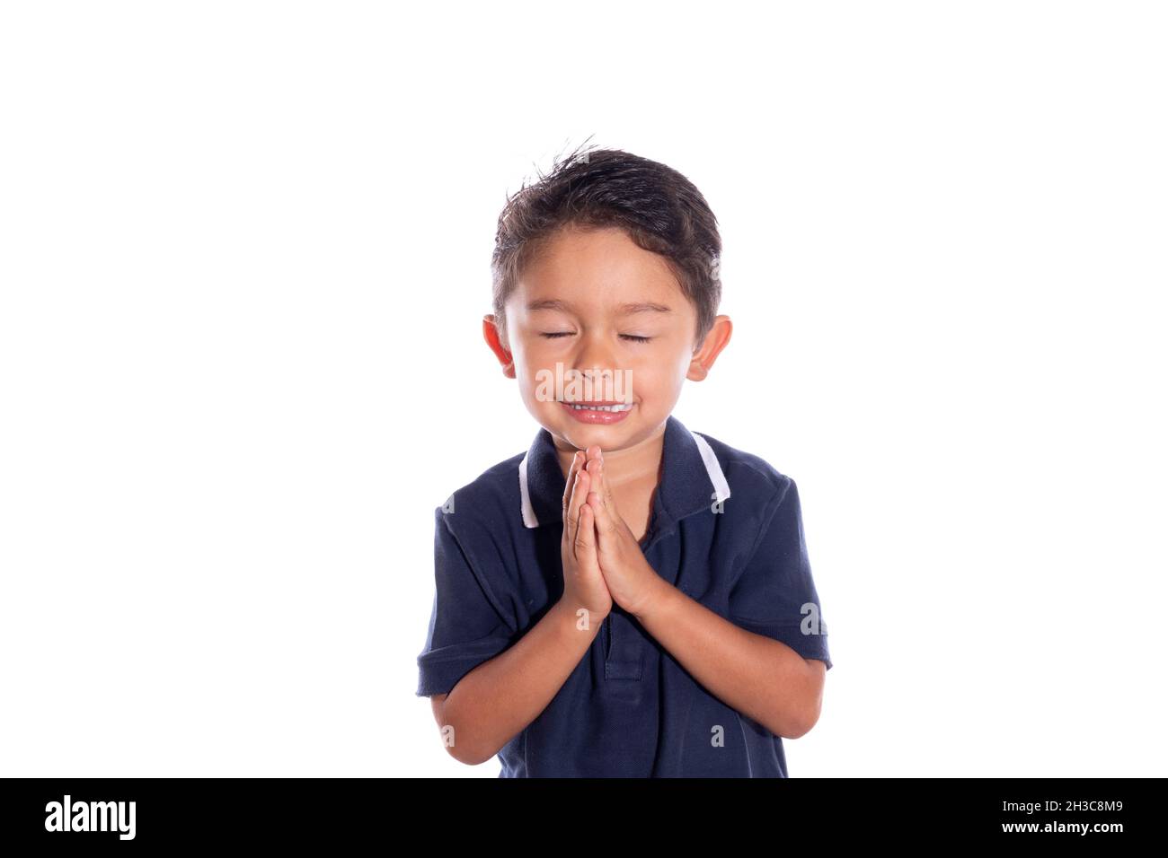 Boy asking for forgiveness with closed eyes, isolated on white ...