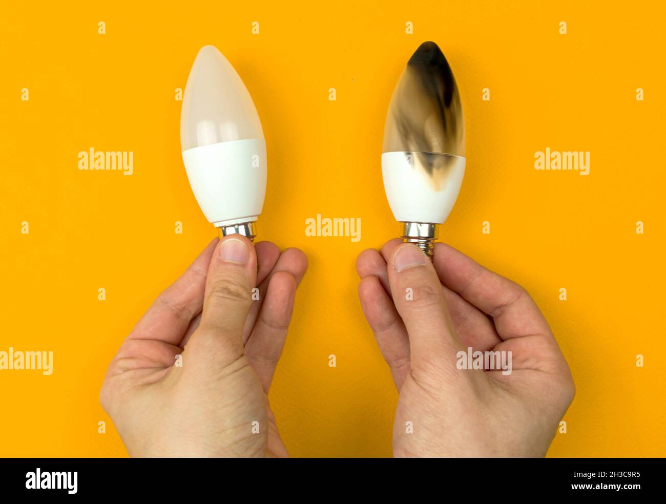 Hands with burned LED light bulbs. Concept of electrical short circuit ...