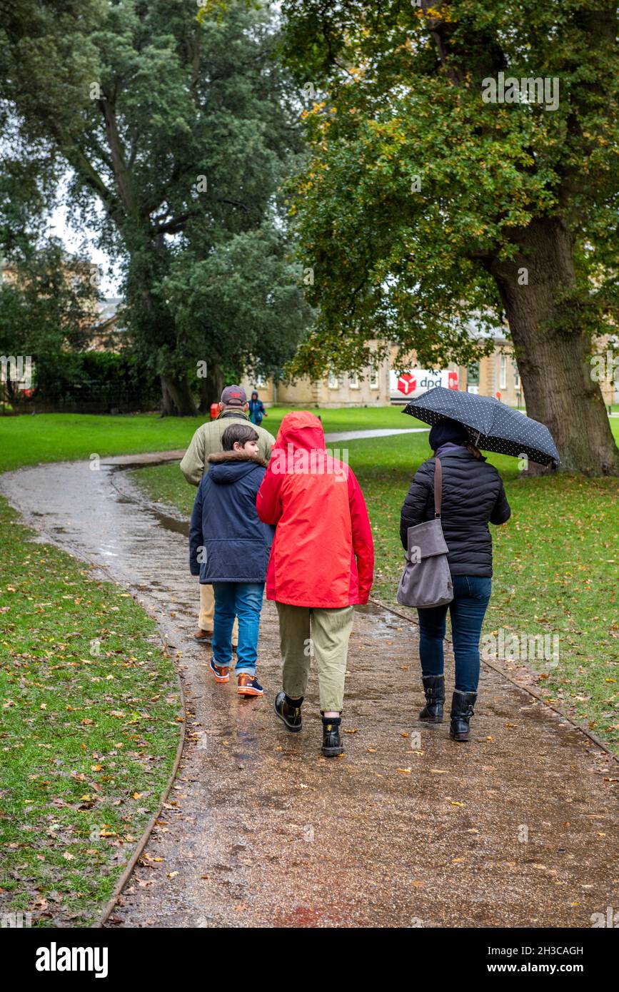 family walking in the rain, wet weather, family walking together with ...