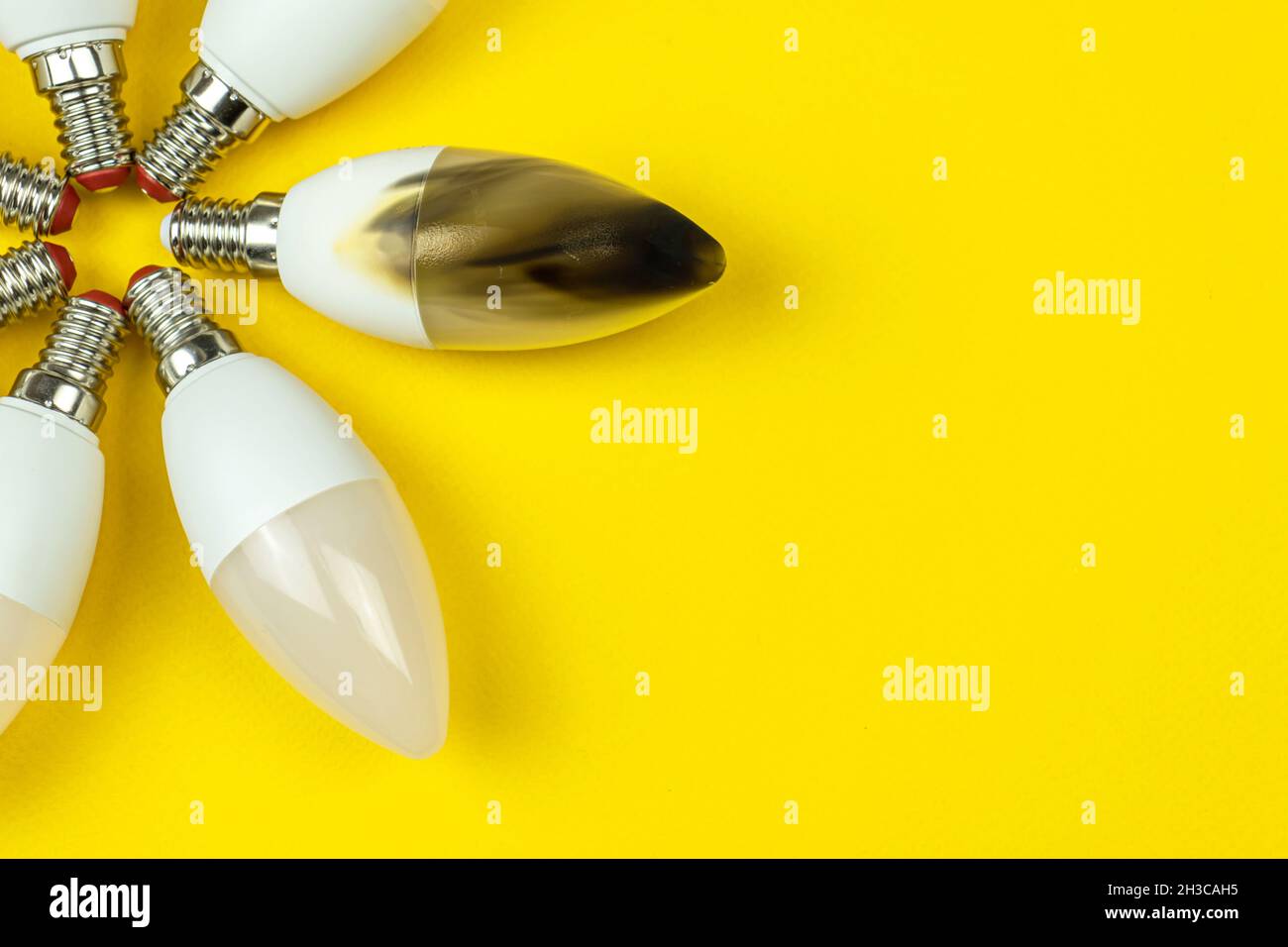 Home safety concept. Broken and burn out LED light bulb after fire. Top ...