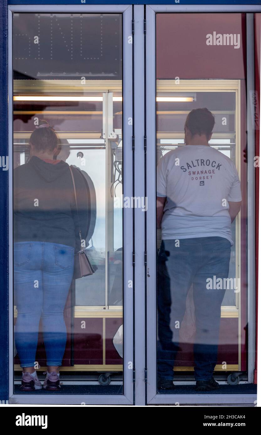 overweight obese man and woman couple standing in an amusement arcade ...