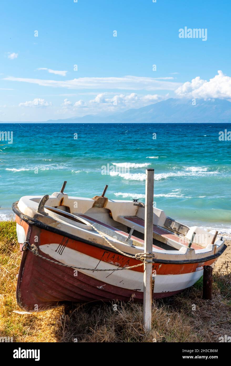 Small dinghy or rowing boat stranded on the beach of a tropical or ...